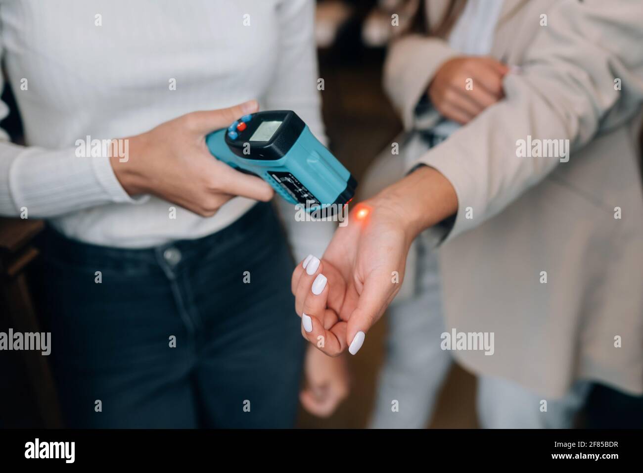 Measuring body temperature with contactless body thermometer Stock ...