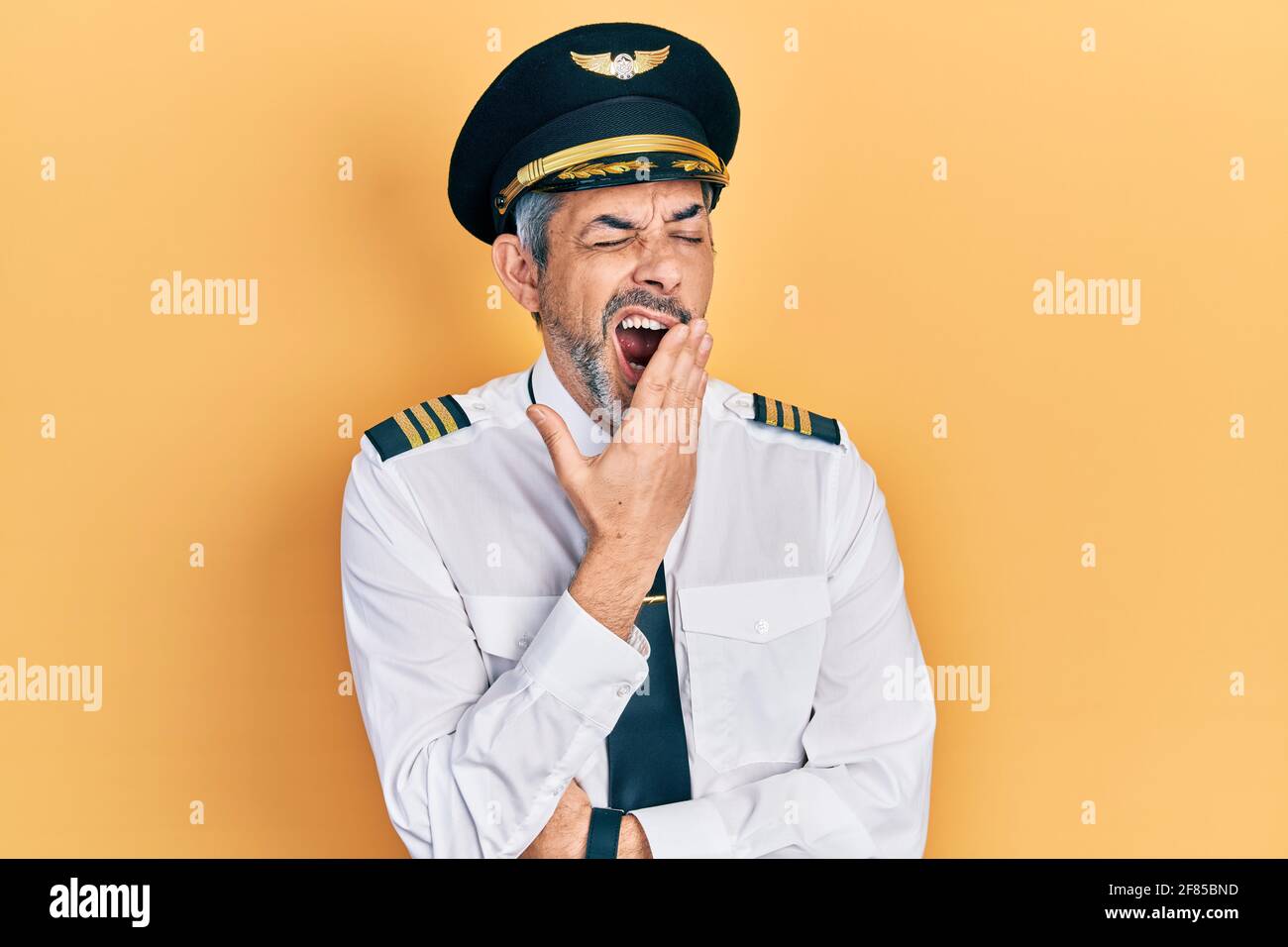 Handsome middle age man with grey hair wearing airplane pilot uniform ...