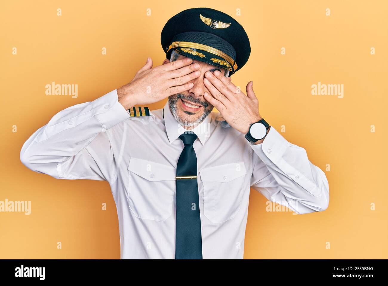 Handsome middle age man with grey hair wearing airplane pilot uniform ...