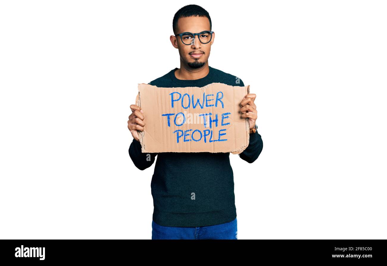 Young african american man holding power to the people banner relaxed ...