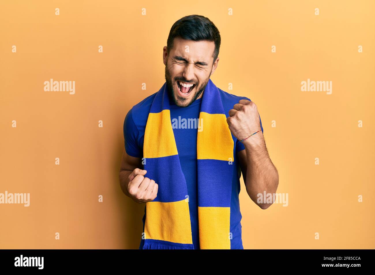 Young hispanic man football hooligan cheering game celebrating ...