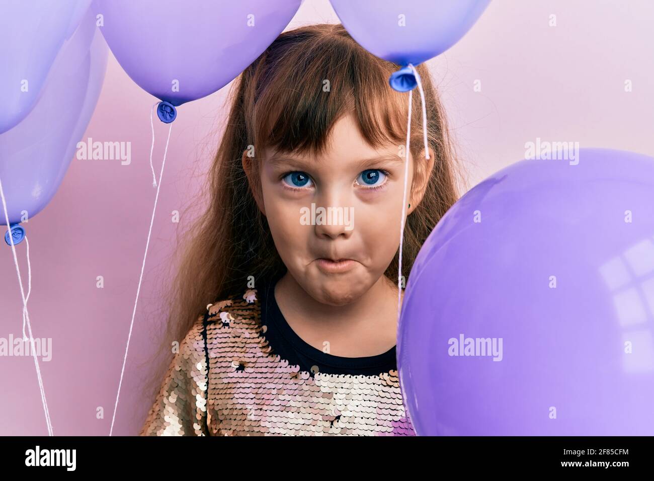 Little caucasian girl kid holding balloons depressed and worry for ...