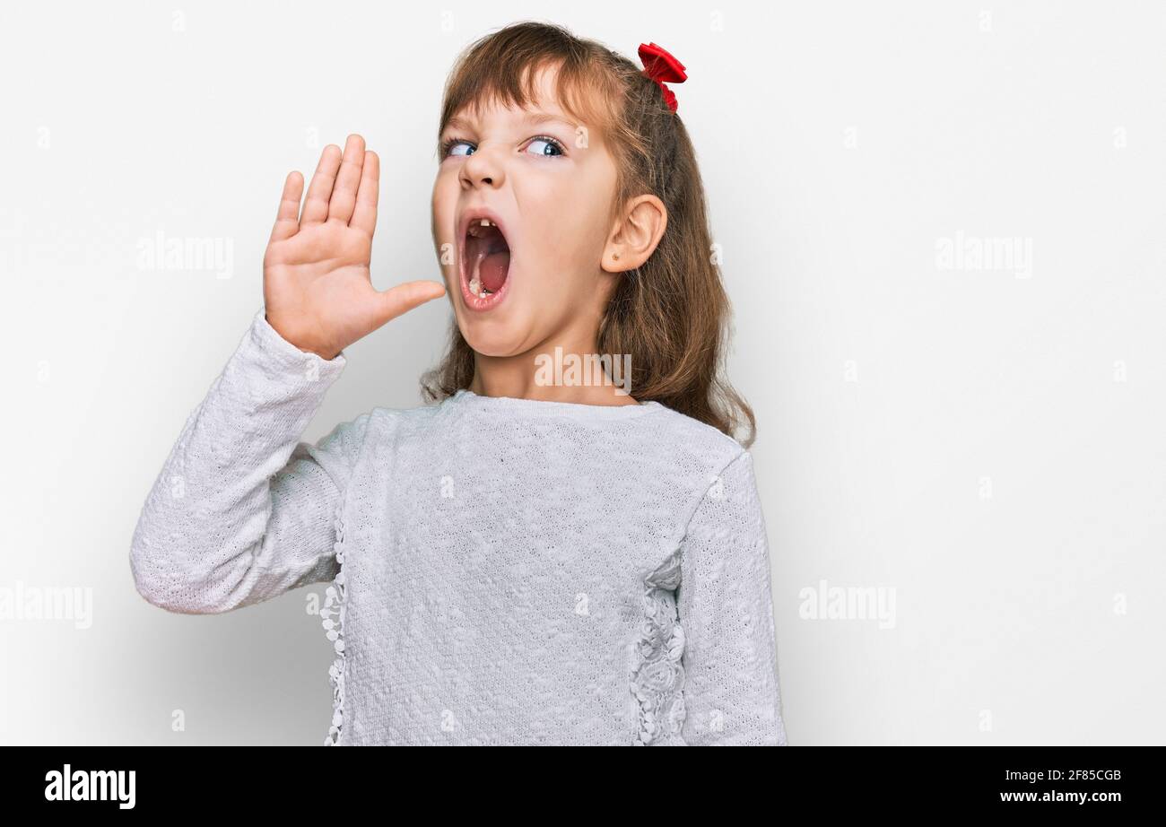 Little caucasian girl kid wearing casual clothes shouting and screaming ...