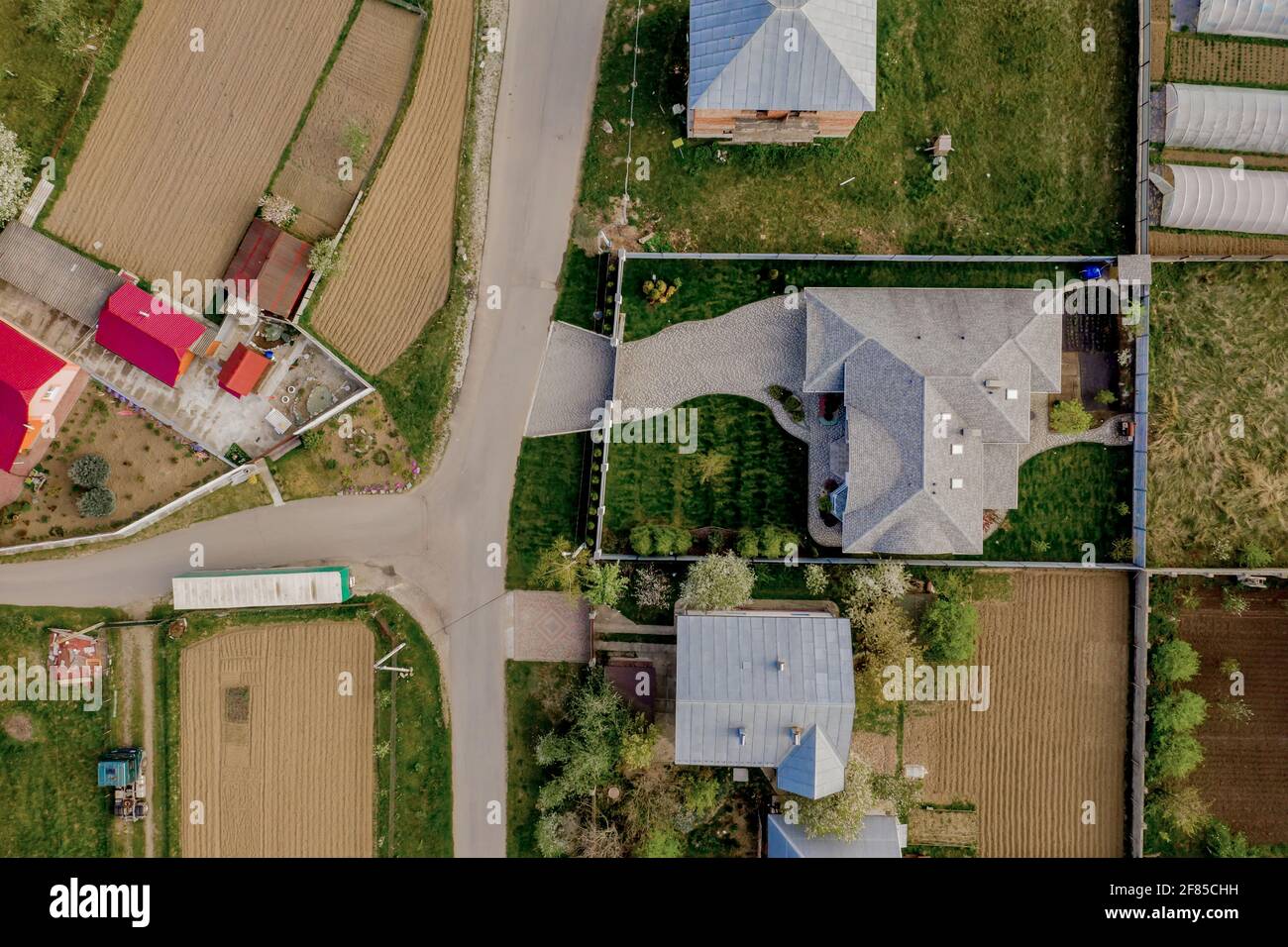 Aerial top view of a house with paved yard with green grass lawn with ...