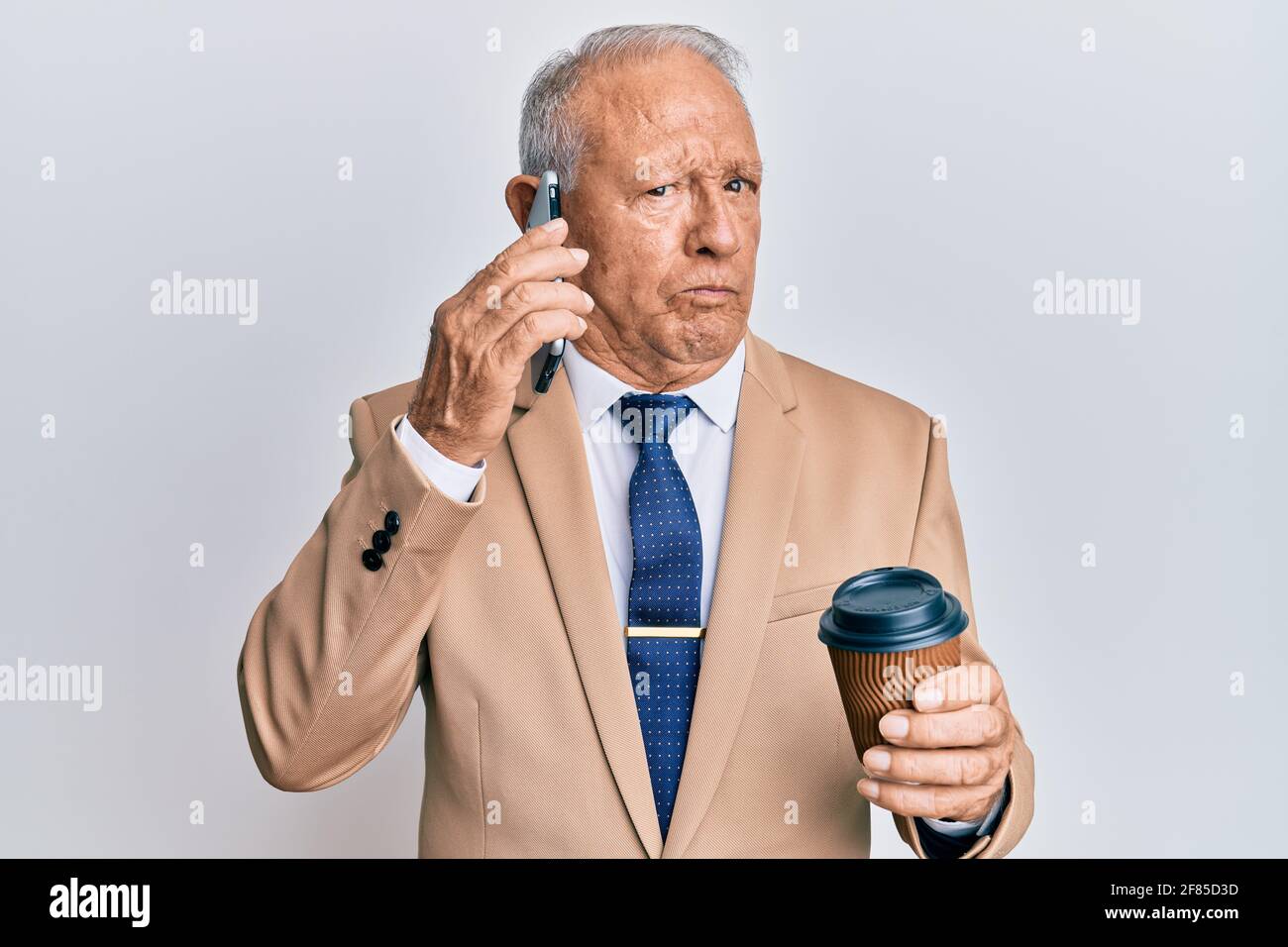 Senior caucasian man talking on the smartphone and drinking a cup of ...