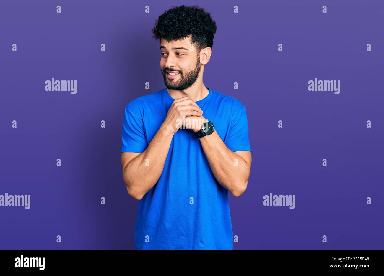 Young arab man with beard wearing casual blue t shirt laughing nervous ...