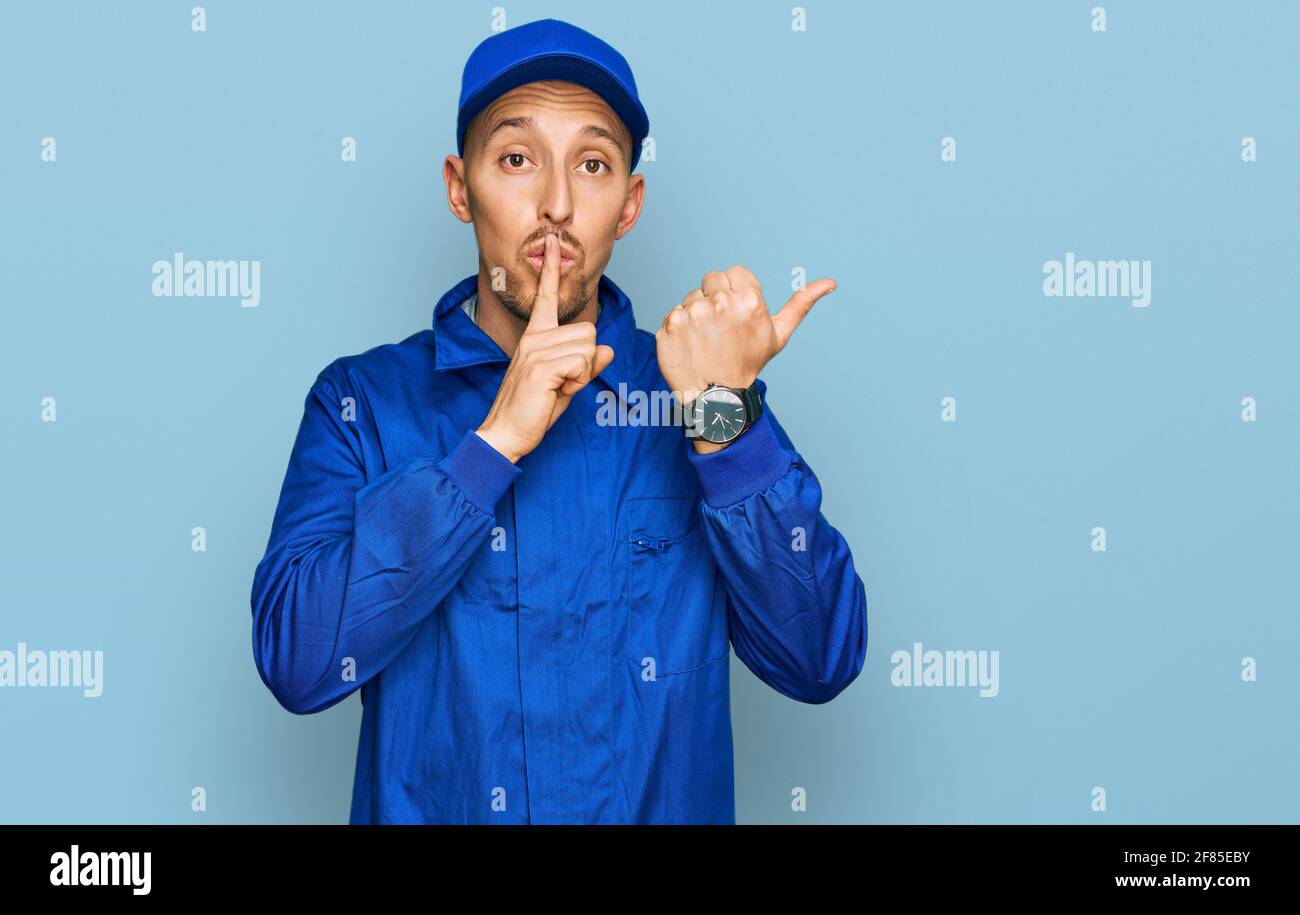 Bald man with beard wearing builder jumpsuit uniform asking to be quiet ...