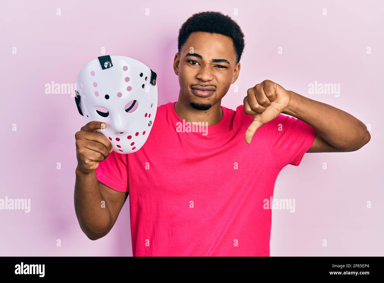 Young african american man holding hockey mask with angry face ...