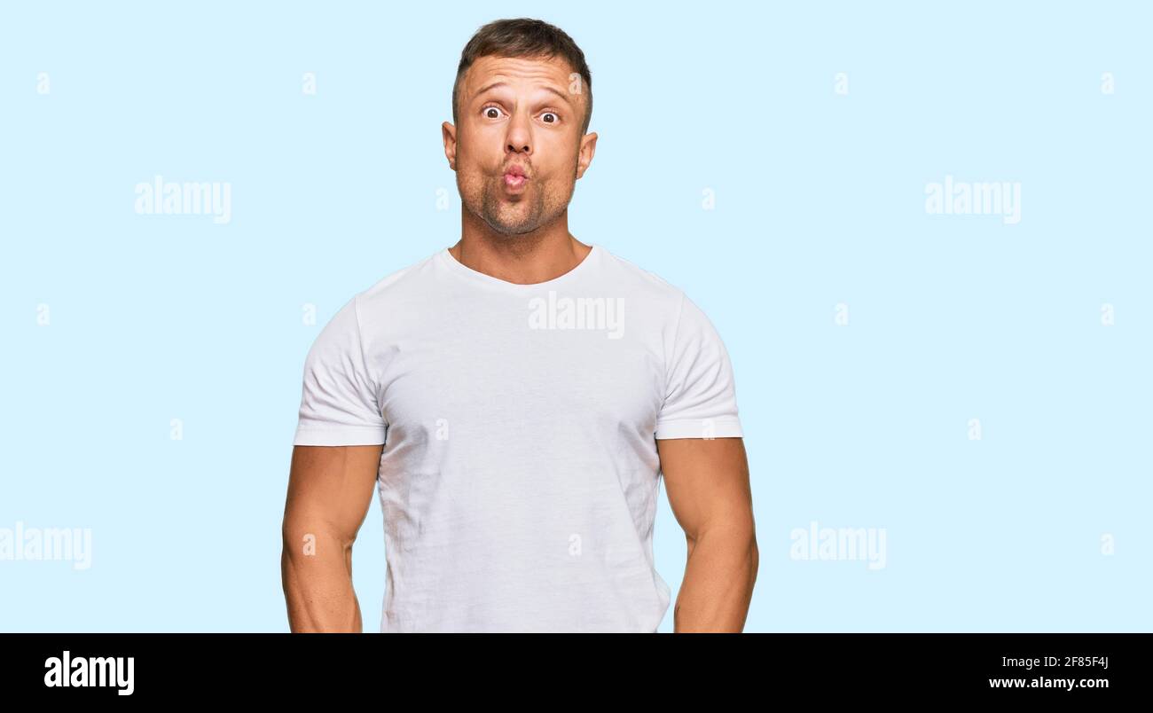 Handsome muscle man wearing casual white tshirt making fish face with ...