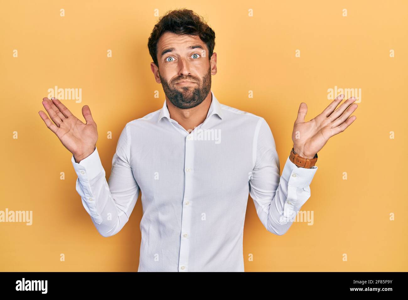 Handsome man with beard wearing casual white t shirt clueless and ...
