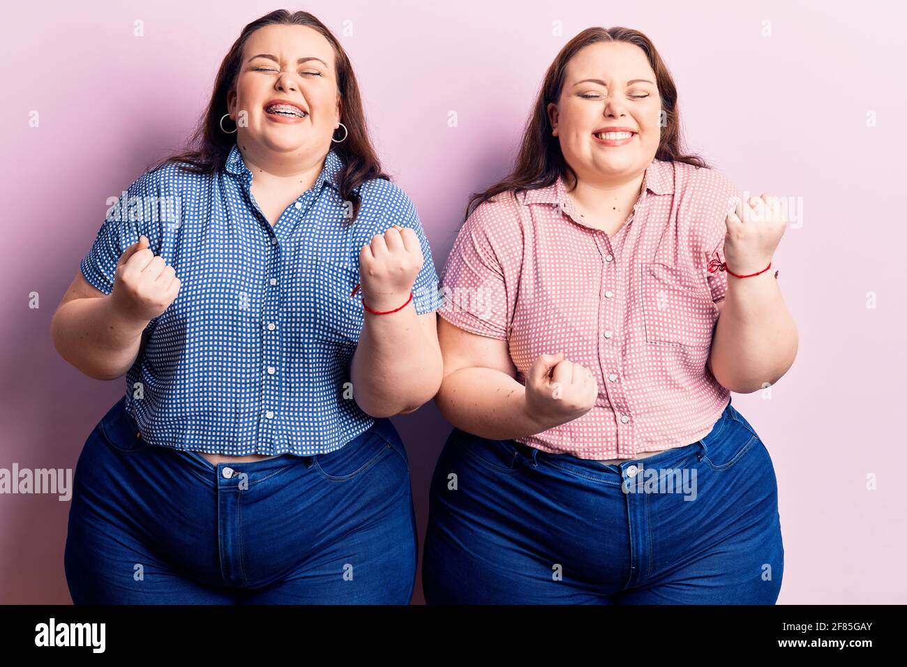 Young plus size twins wearing casual clothes celebrating surprised and ...