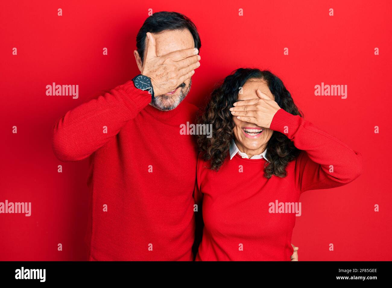 Middle age couple of hispanic woman and man hugging and standing ...