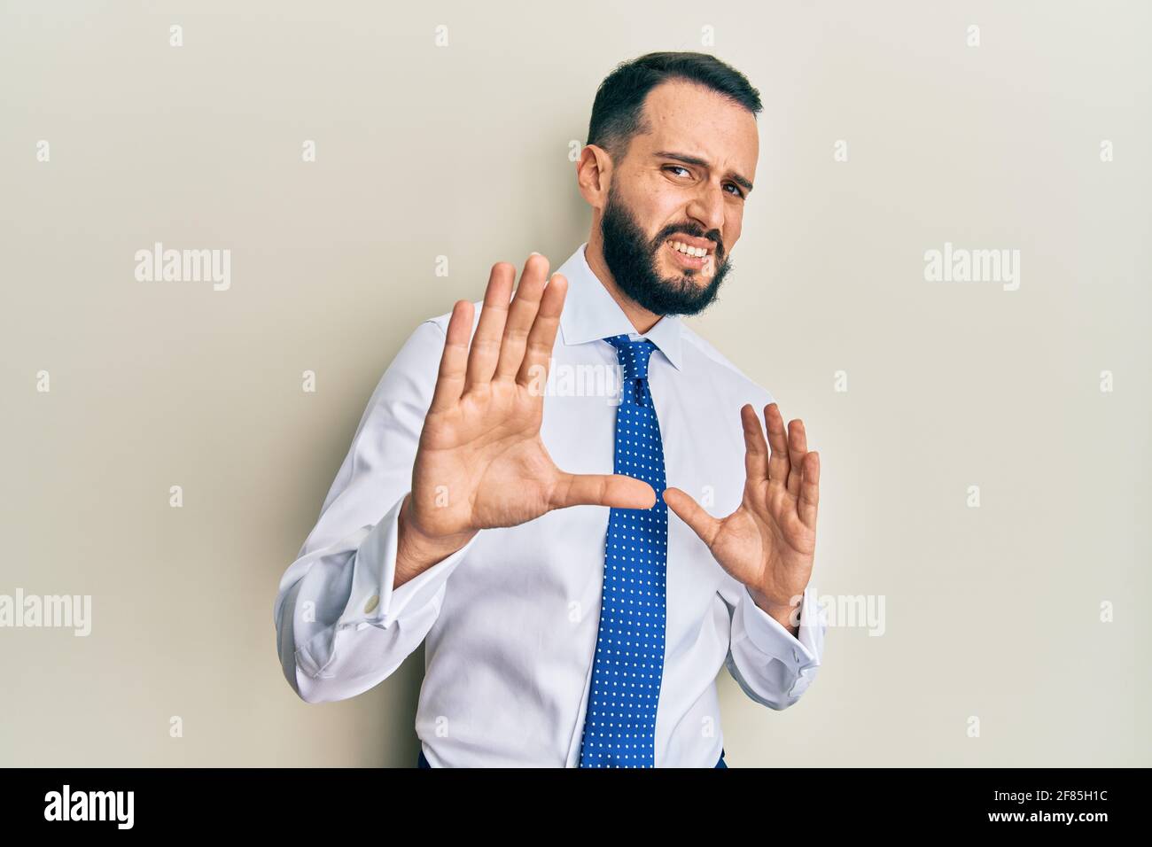 Young man with beard wearing business tie disgusted expression ...