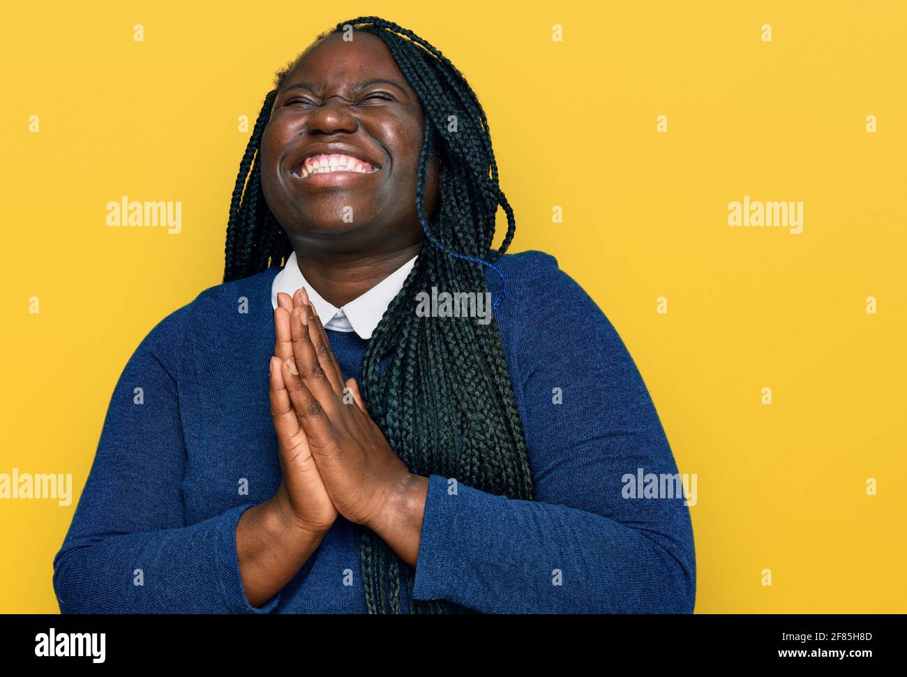Young black woman with braids wearing casual clothes begging and ...