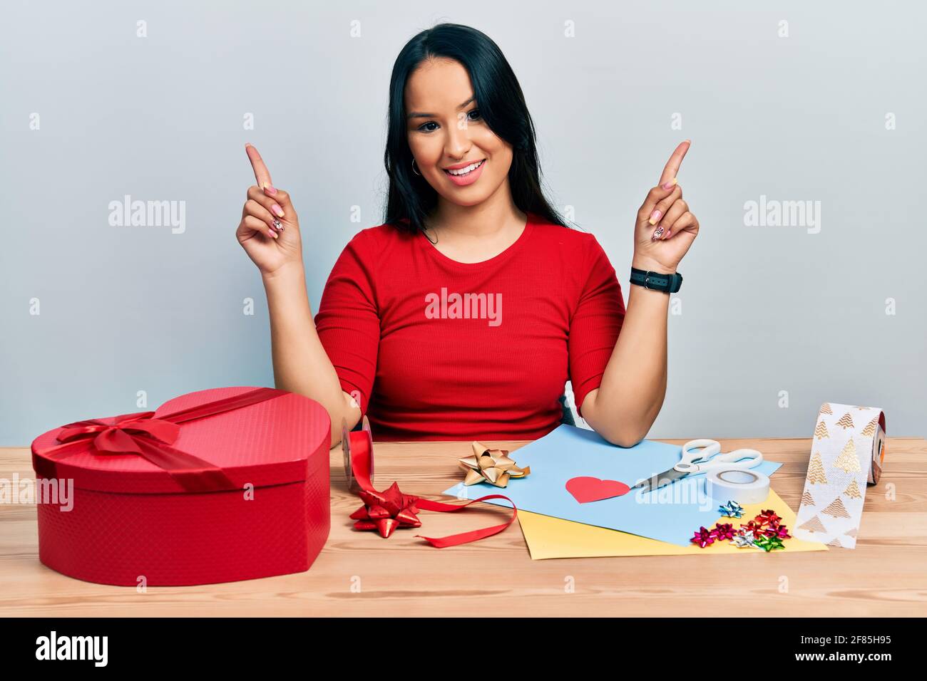 Beautiful hispanic woman with nose piercing doing handcraft creative ...