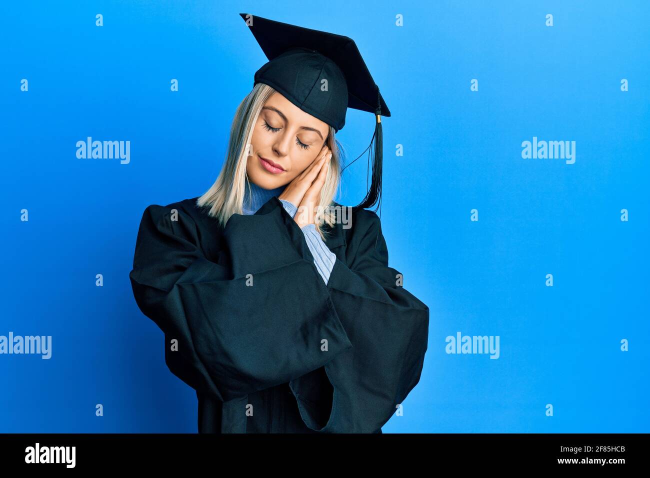 Beautiful blonde woman wearing graduation cap and ceremony robe ...