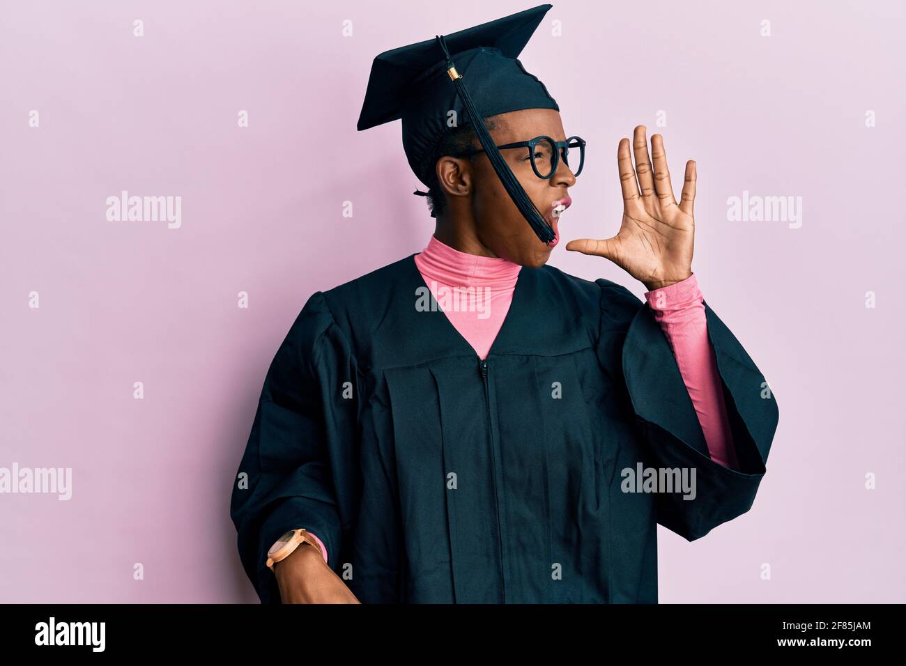 Young african american girl wearing graduation cap and ceremony robe ...
