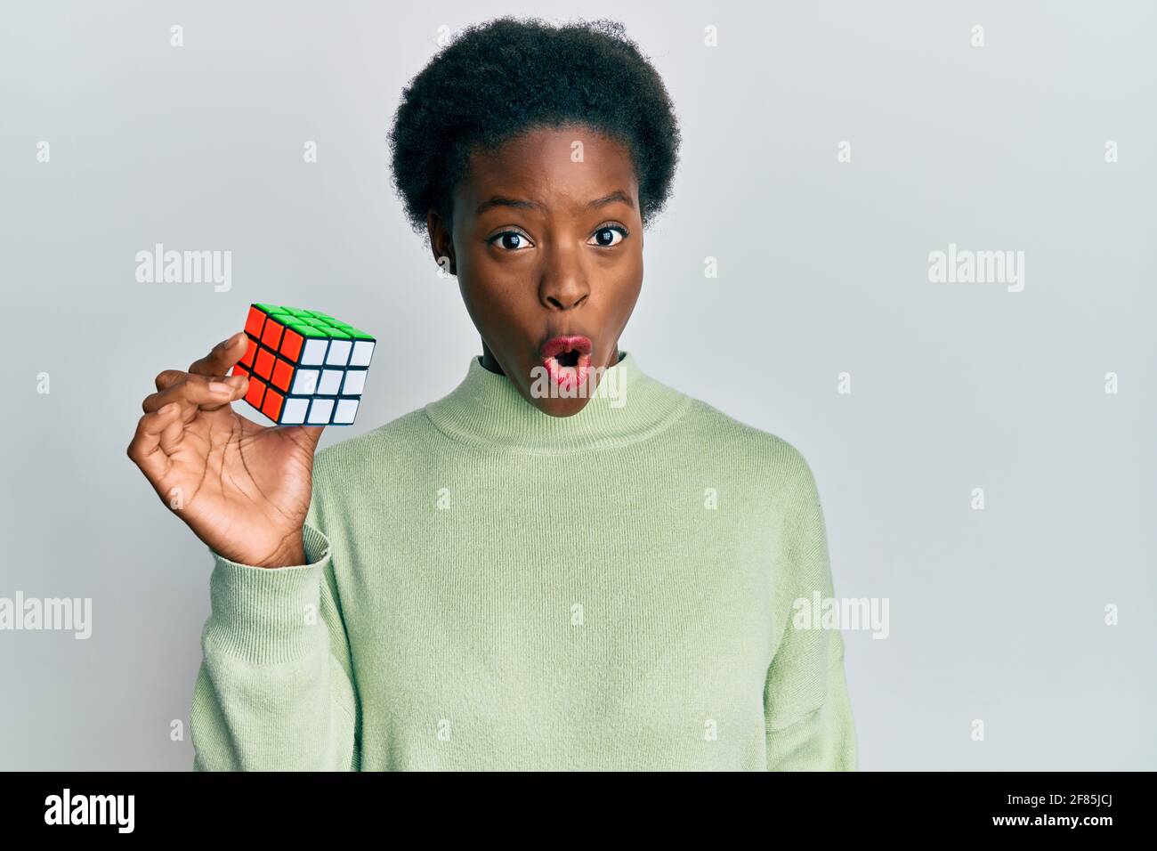 Young african american girl playing colorful puzzle cube intelligence ...