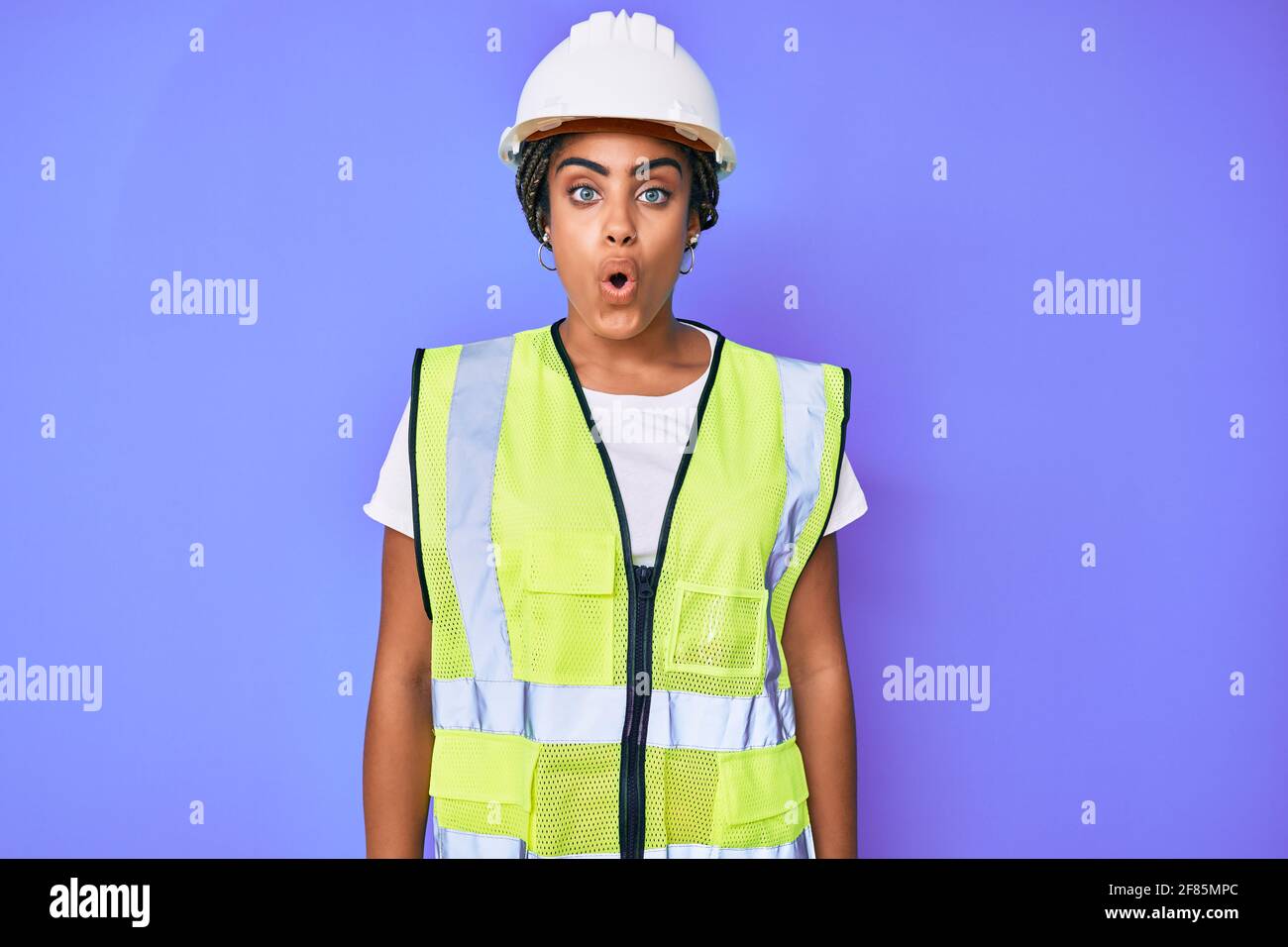 Young african american woman with braids wearing safety helmet and ...