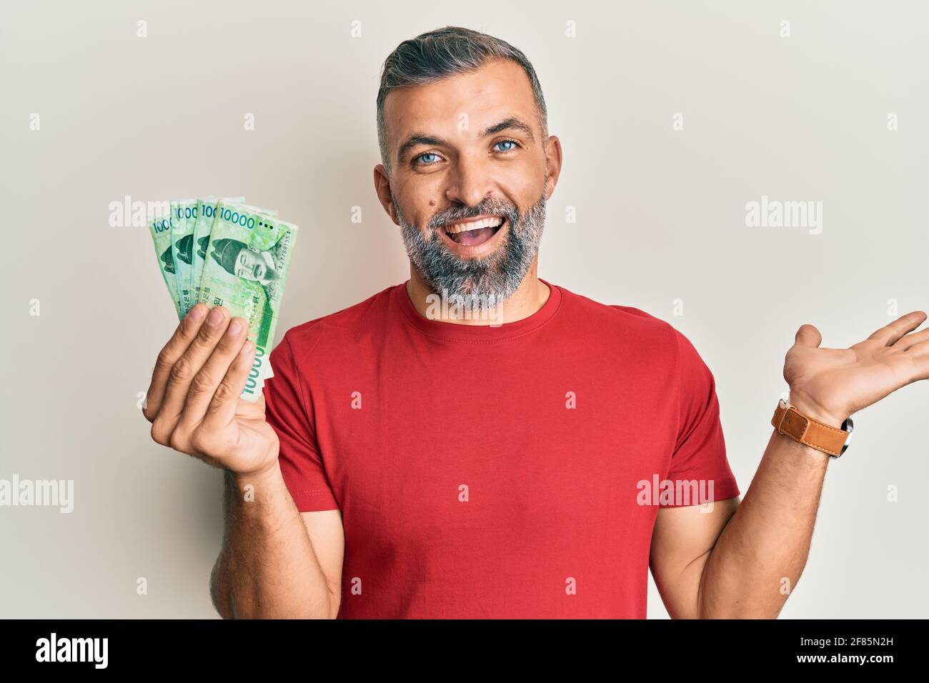 Middle age handsome man holding 10000 south korean won banknotes ...