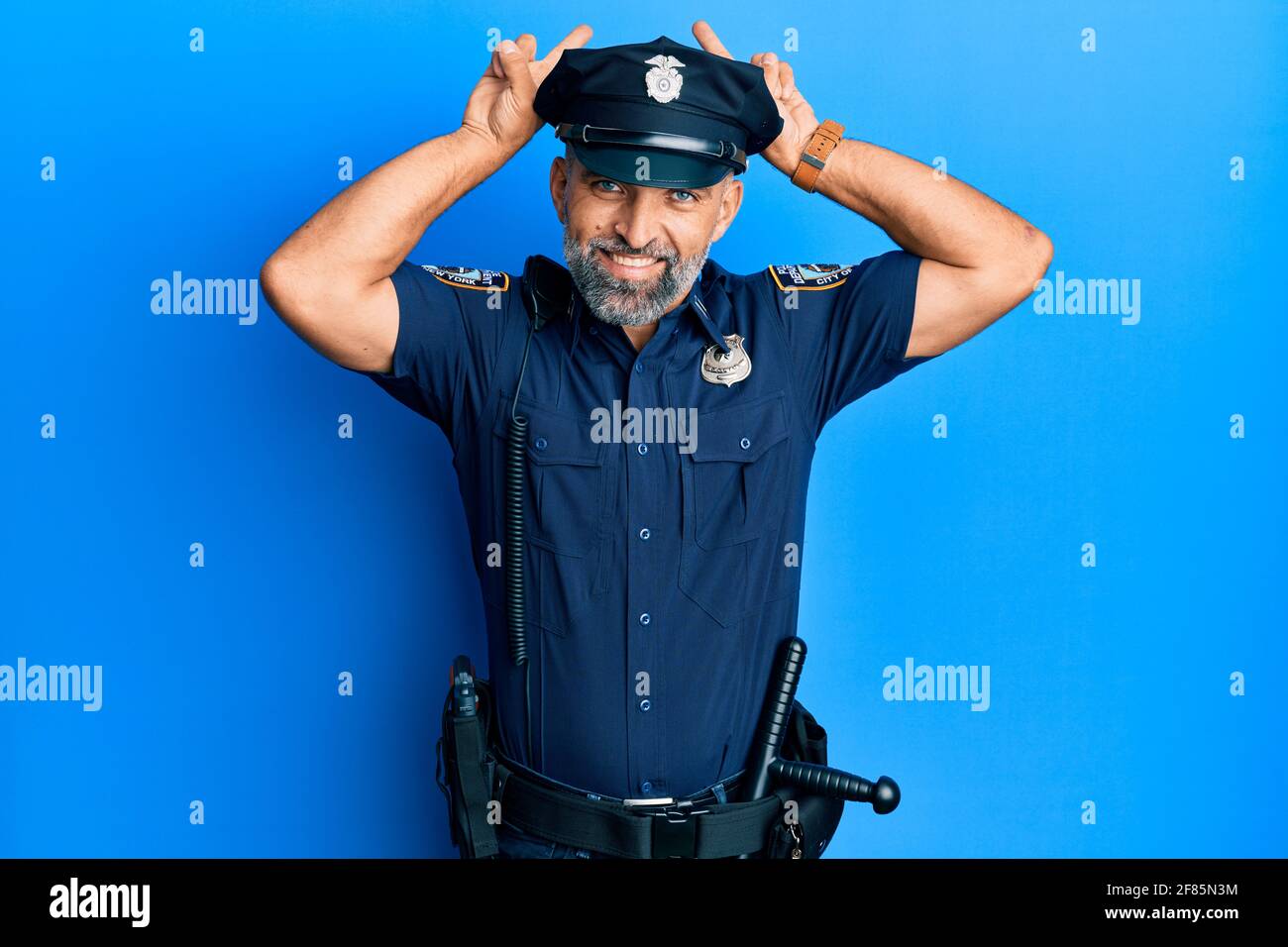 Middle age handsome man wearing police uniform posing funny and crazy ...