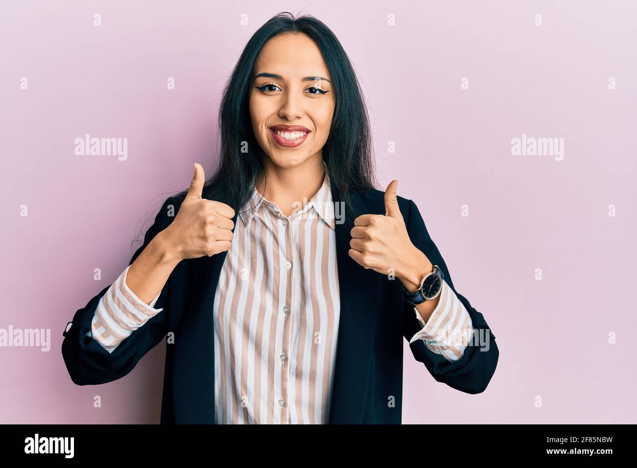 Young hispanic girl wearing business clothes success sign doing ...