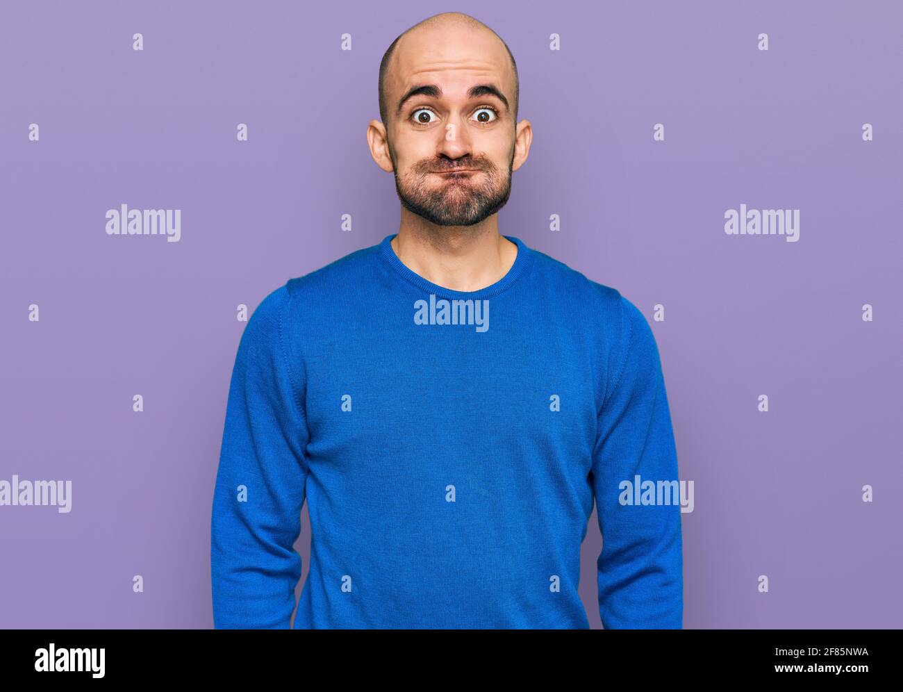 Young hispanic man wearing casual clothes puffing cheeks with funny ...
