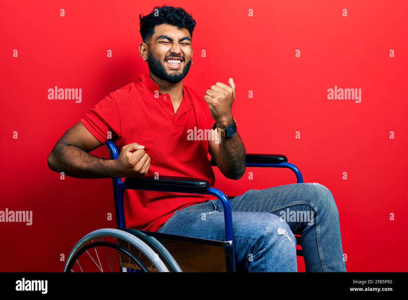 Arab man with beard sitting on wheelchair celebrating surprised and ...