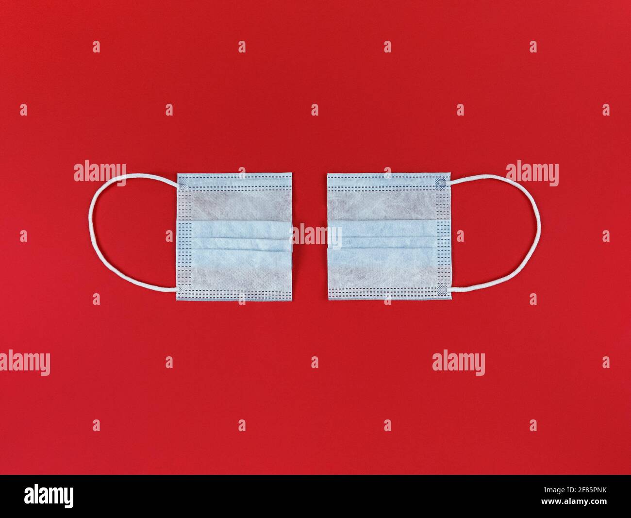 Medical disposable face mask cut in half on red background Stock Photo ...