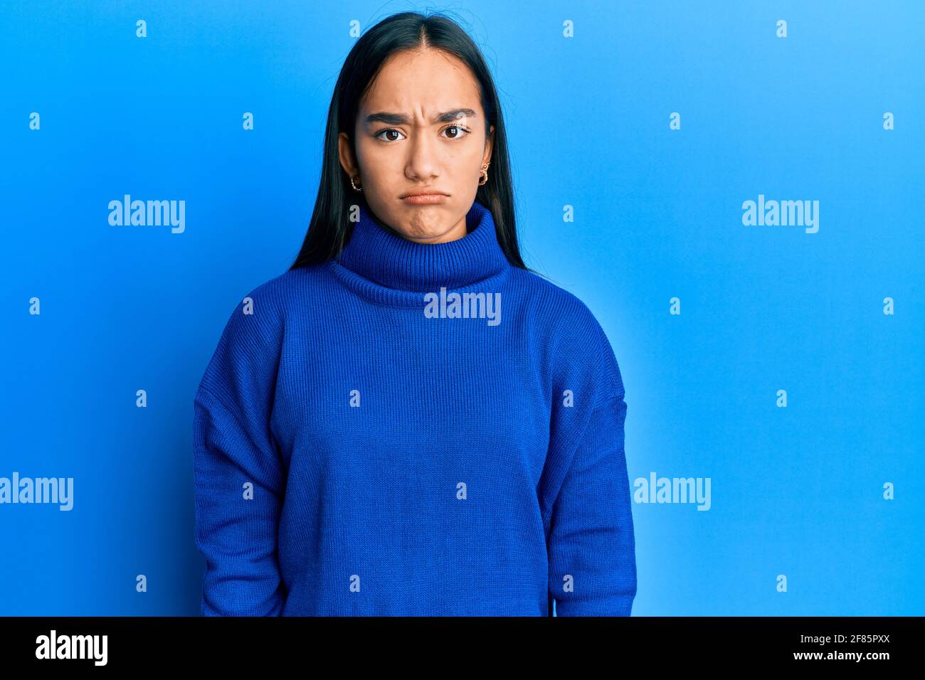 Young asian woman wearing casual winter sweater depressed and worry for ...