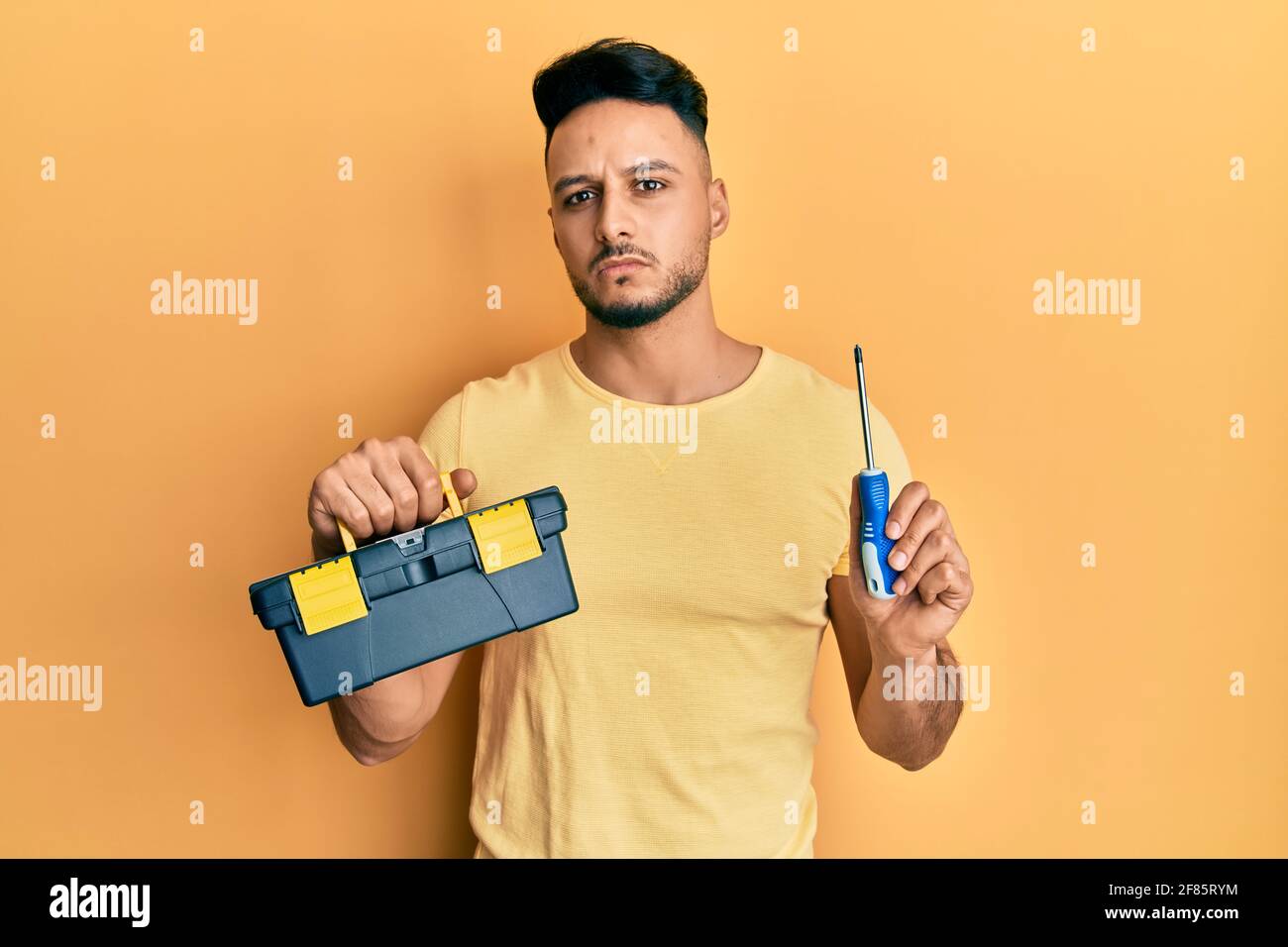 Young arab man holding toolbox and screwdriver depressed and worry for ...