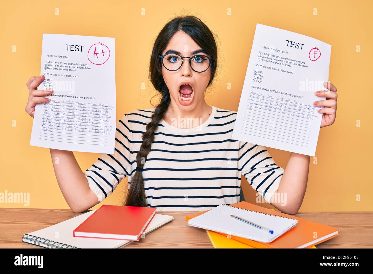 Brunette teenager girl showing failed and passed exam afraid and ...