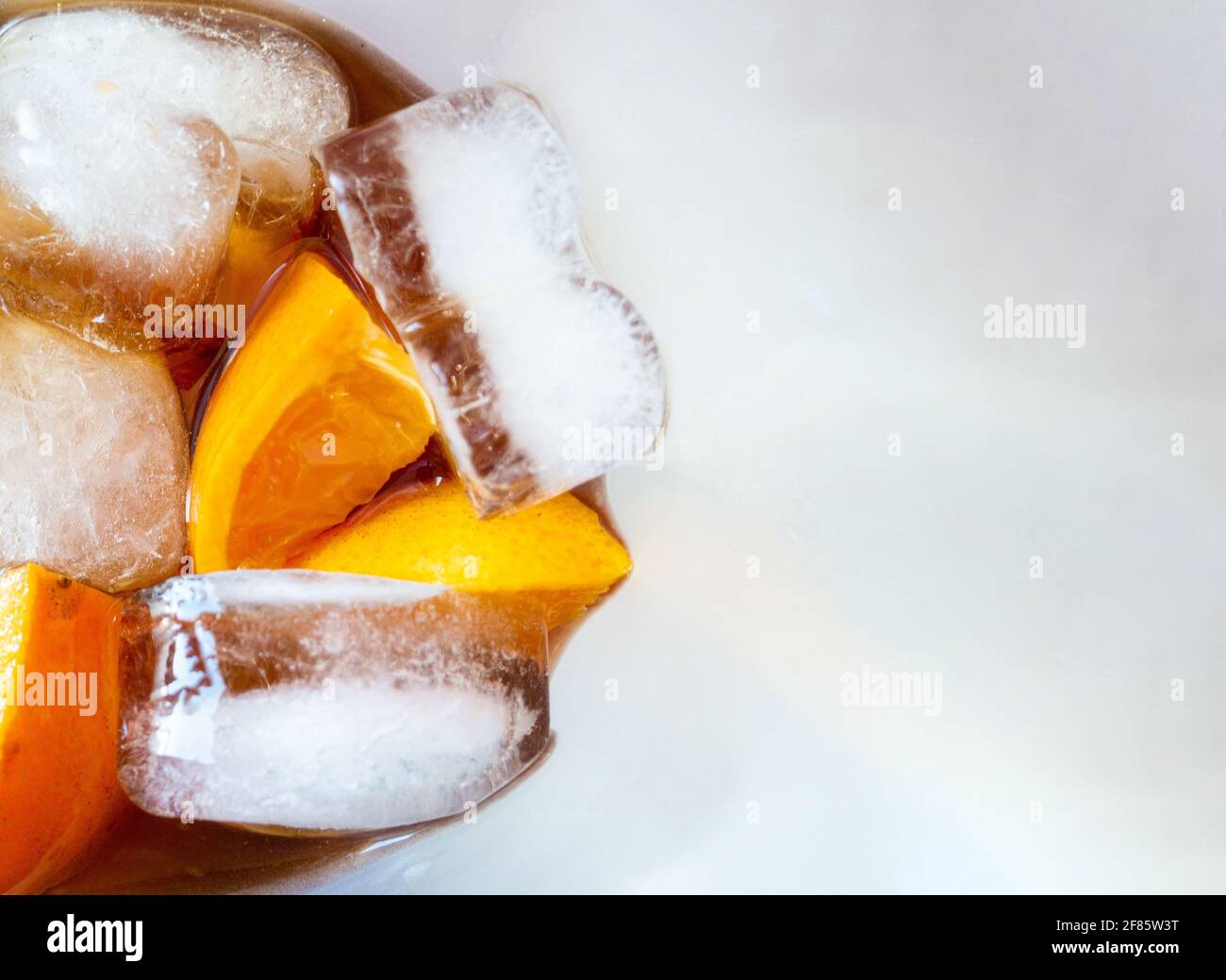 A top closeup view of vermouth glass with ice pieces of fruit on soft ...