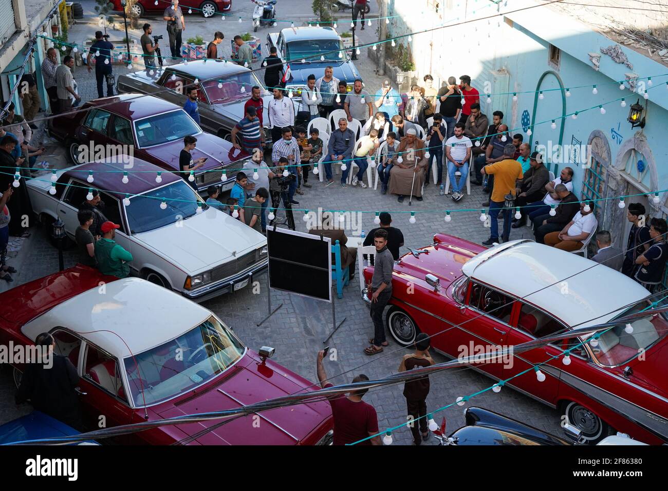 Mosul, Iraq. 11th Apr, 2021. People gather around vintage cars in the ...