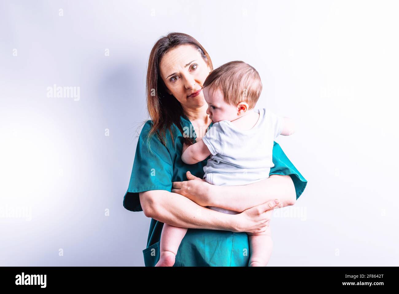 Hospital doctor holding a six month old baby infant hospital concept ...