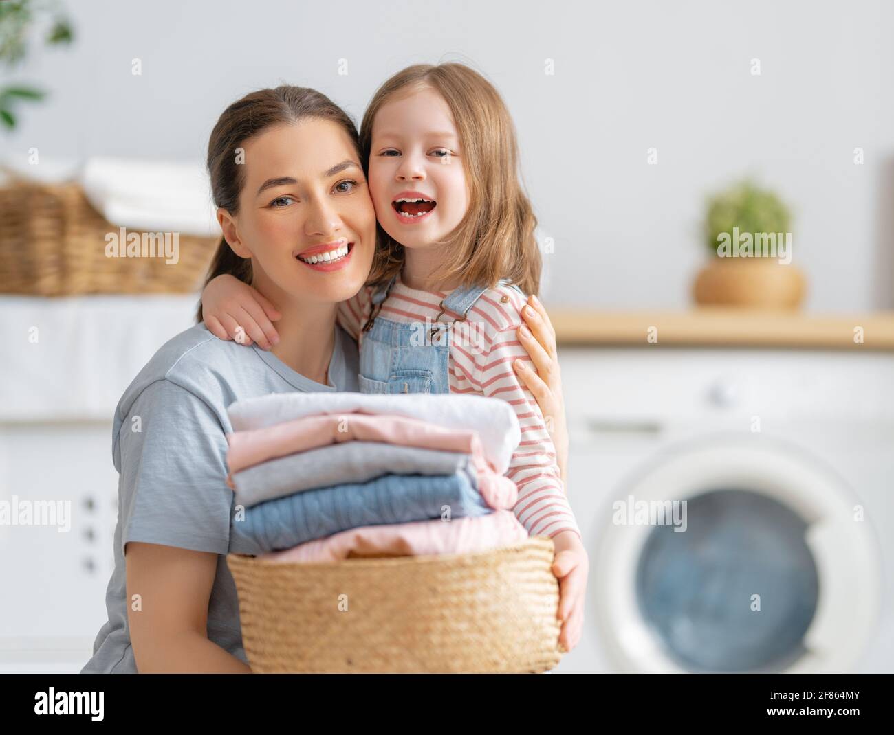 Beautiful young woman and child girl little helper are having fun and ...