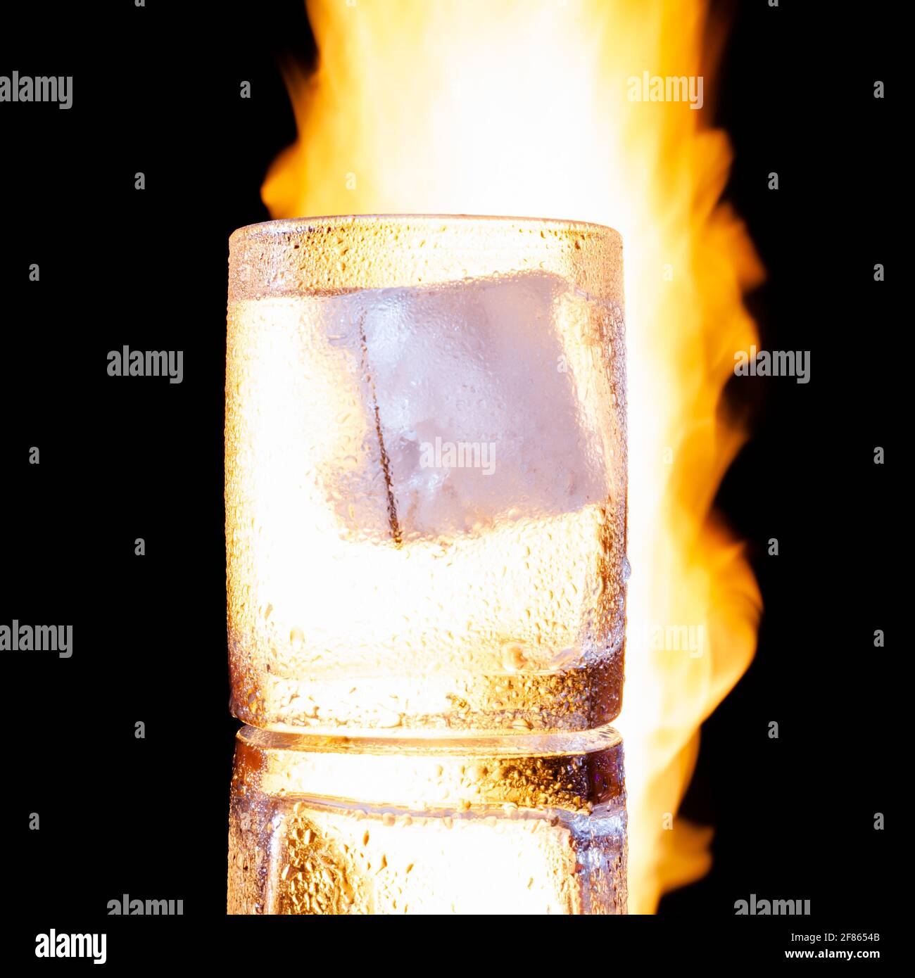 glass of vodka with ice on fire on a black background Stock Photo - Alamy