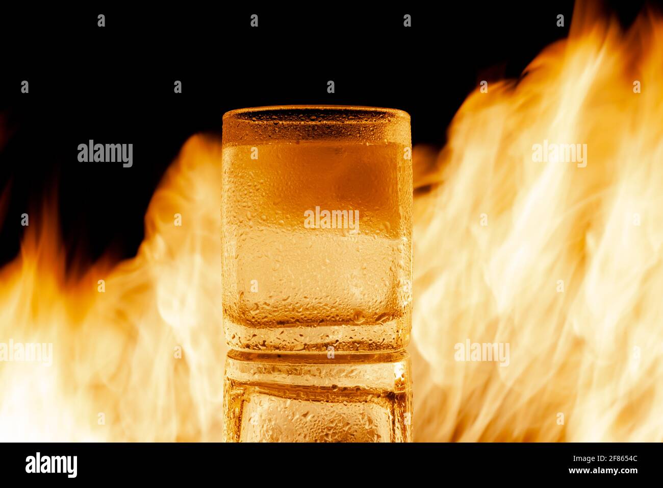 glass of water with ice against the background of fire Stock Photo - Alamy