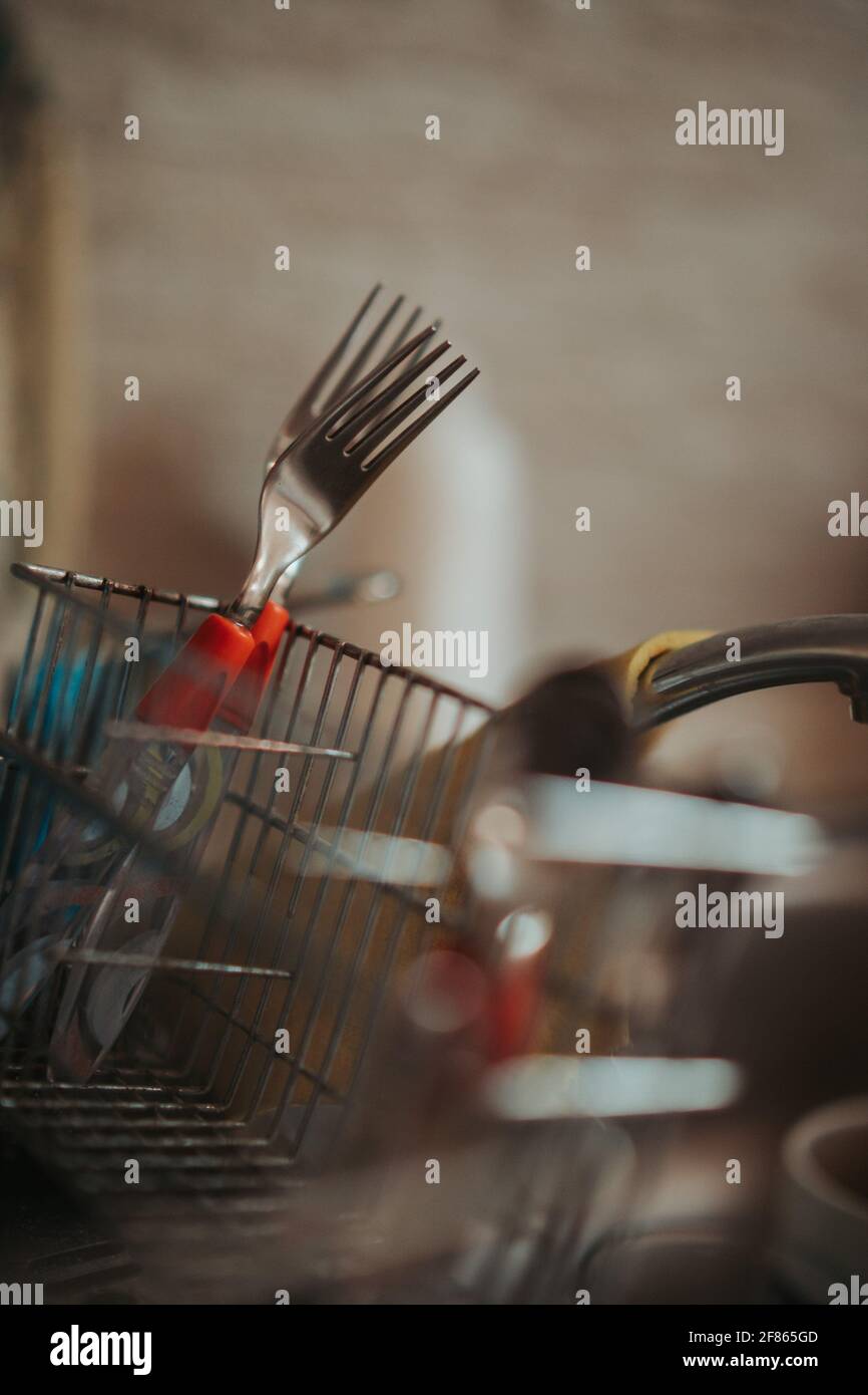 Vertical shot of metal forks put next to the sink on a blurred ...