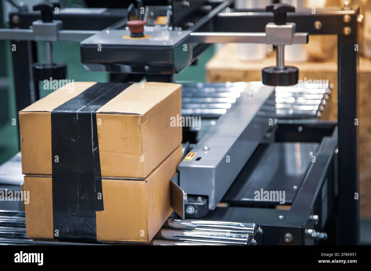 Carton on roller conveyor. Automatic carton tape sealing machine ...