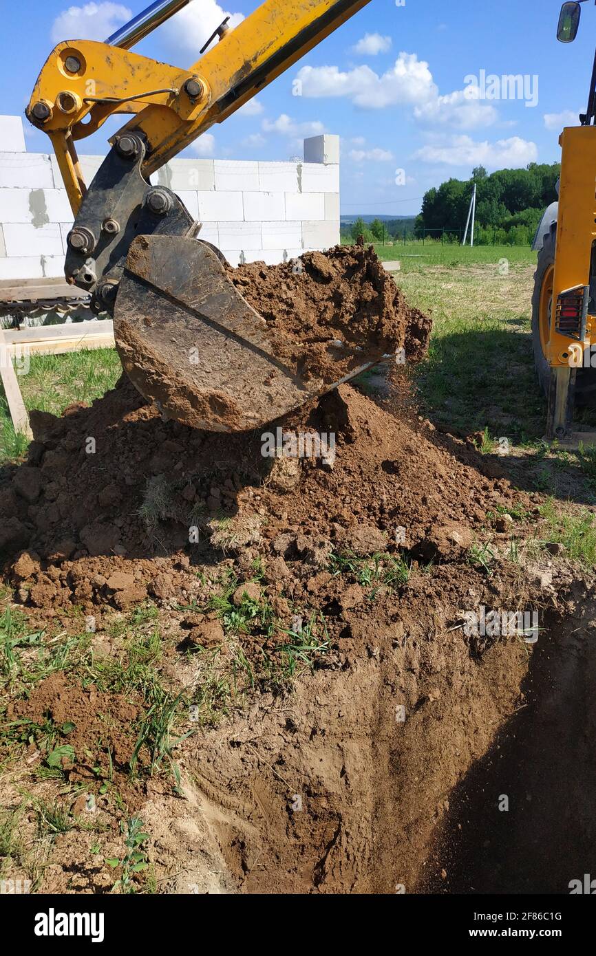 excavator on a construction site digs ditches, the process of work ...