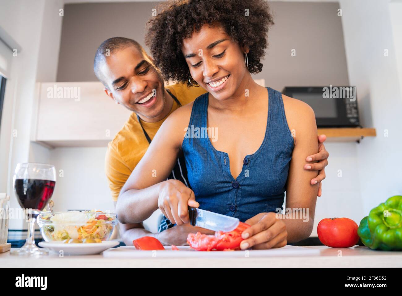 Latin couple cooking together in the kitchen Stock Photo - Alamy