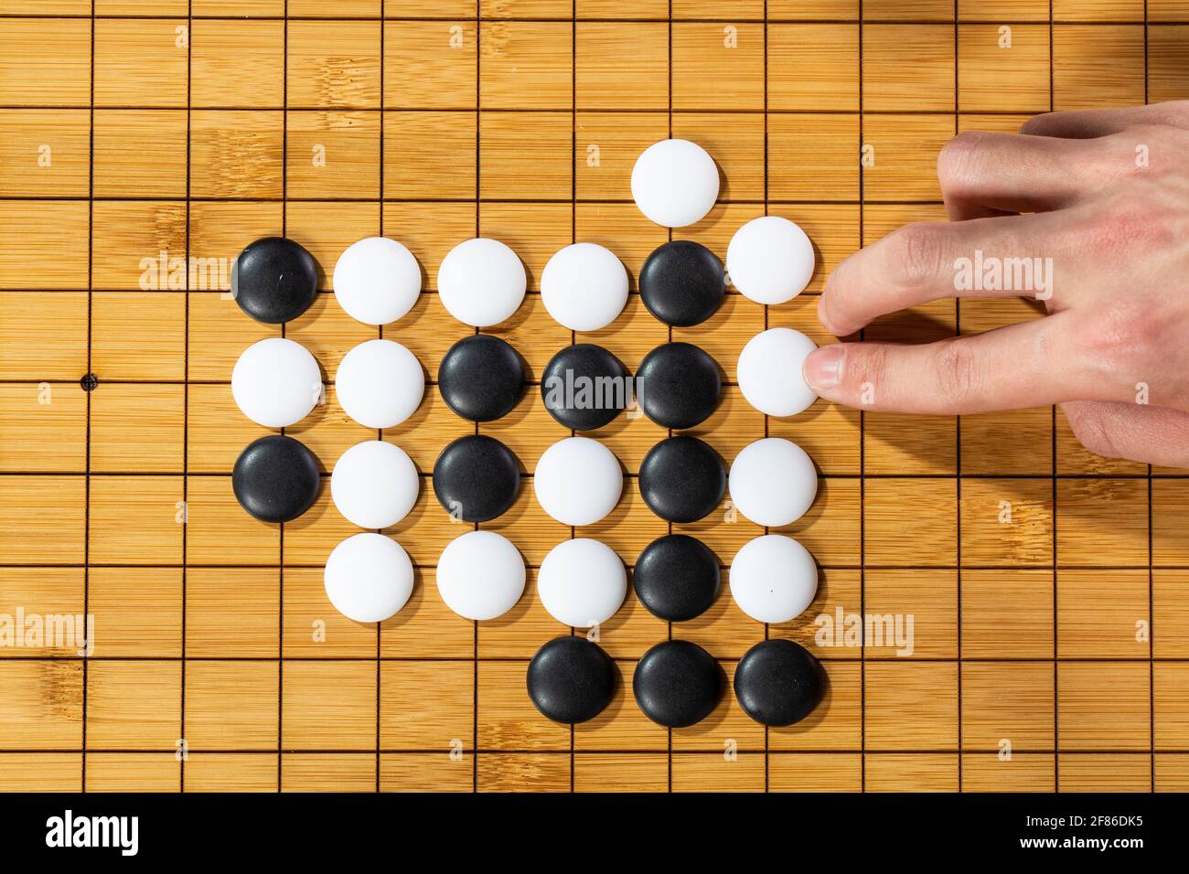 High angle shot of a person sorting black and white checkers pawns on ...