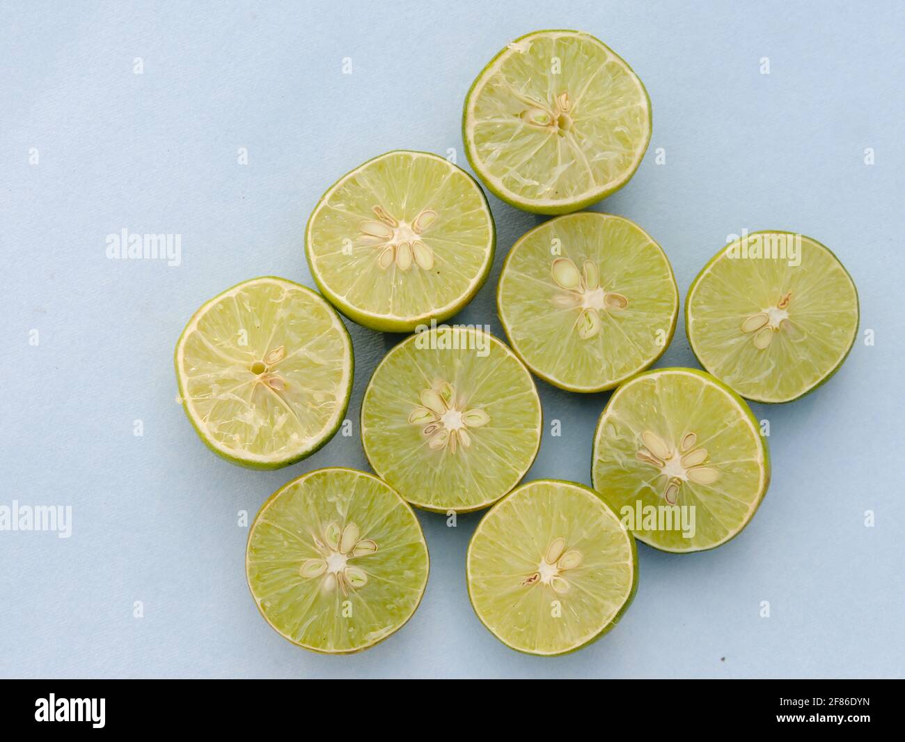 Top down closeup shot of multiple limes sliced in half and facing up on ...
