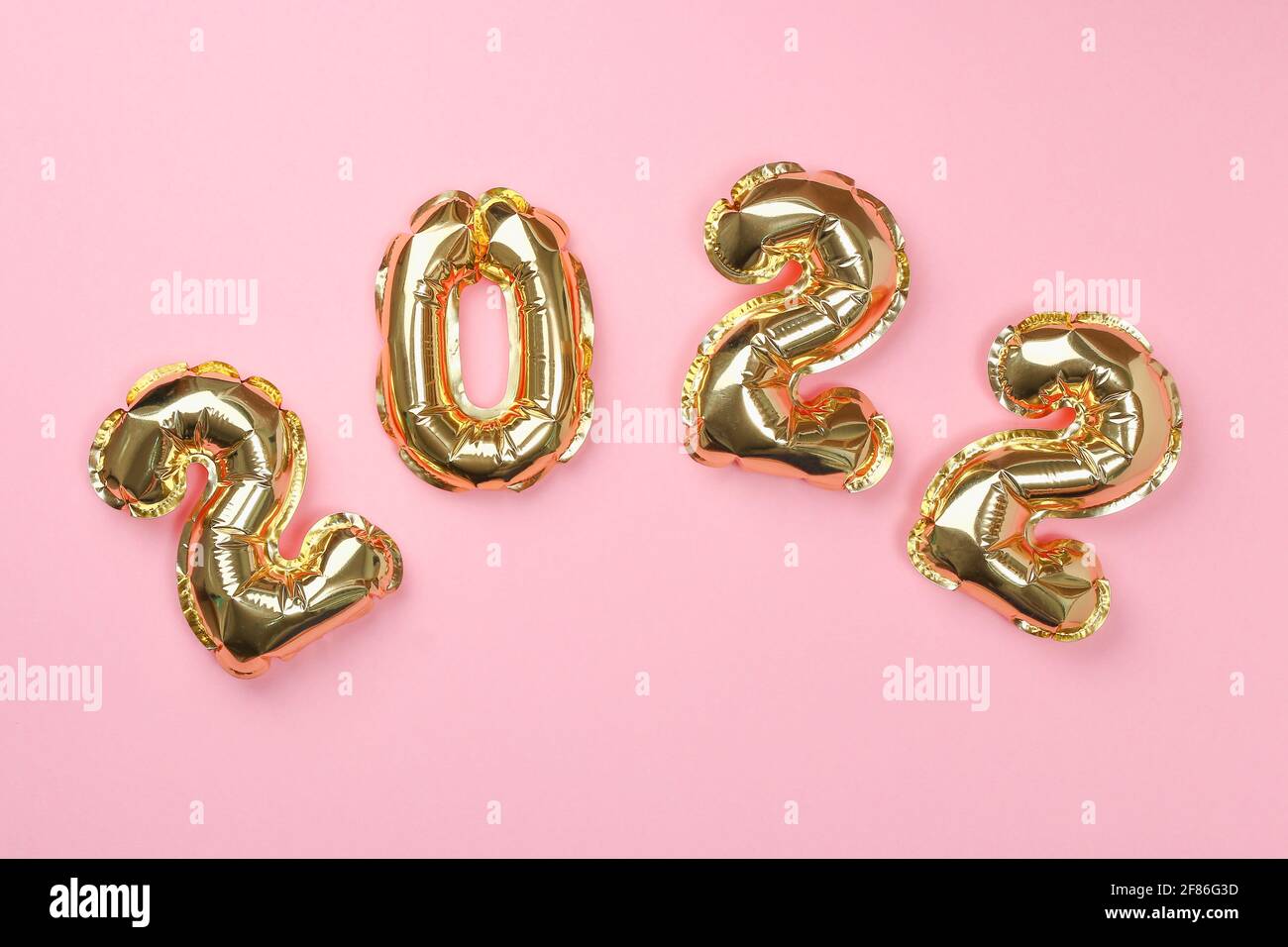 New Year 2022. Foil balloons numbers 2022 on a pink background. New ...