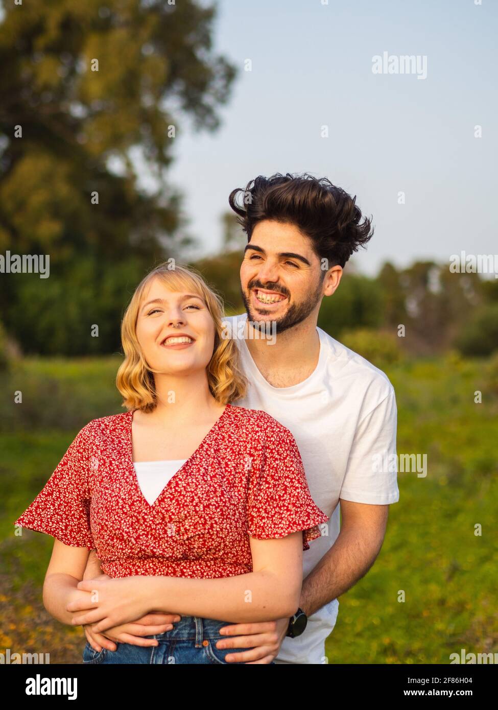 Cheerful young Spanish couple posing together while having fun in the ...