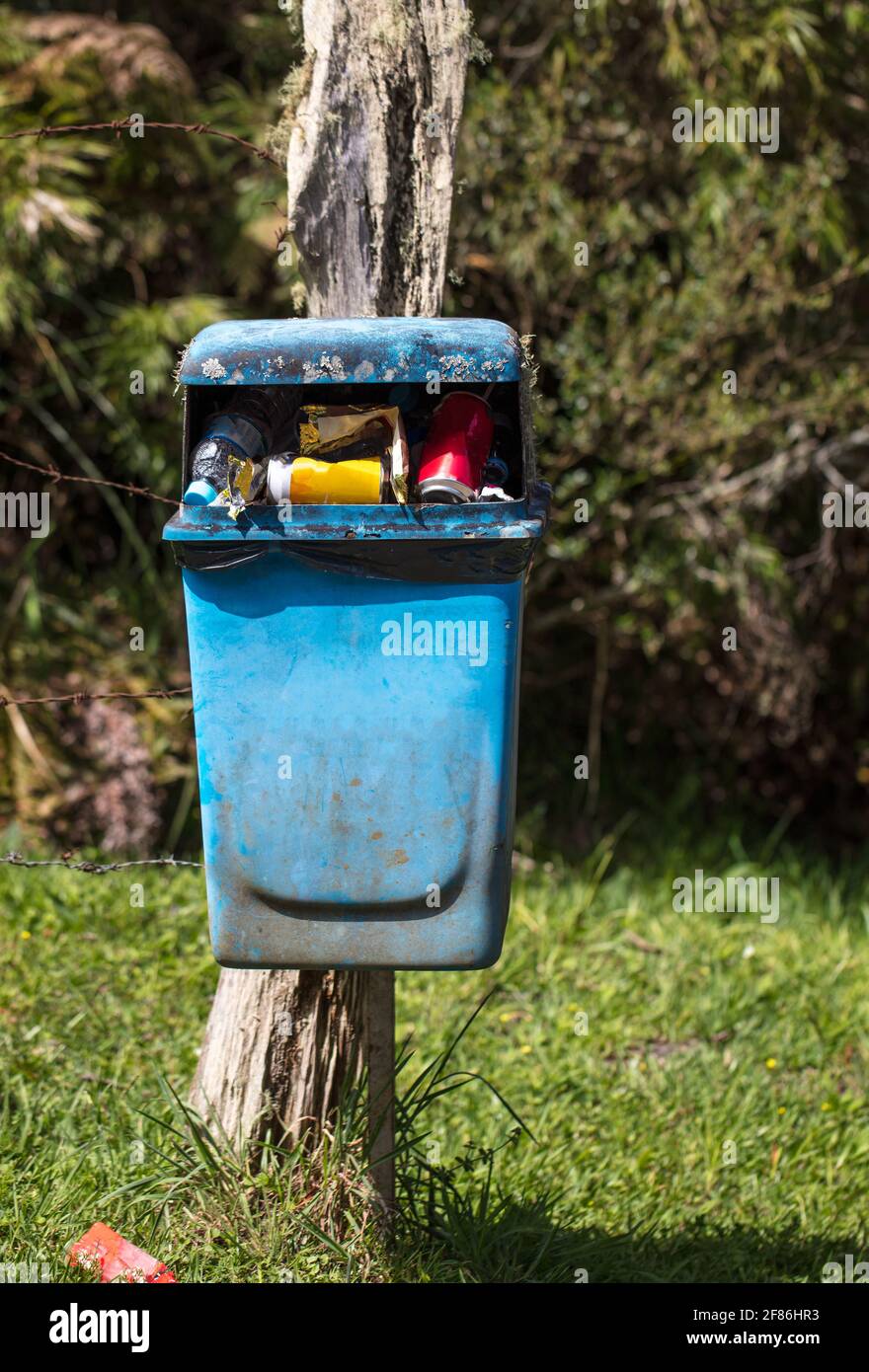 Vertical shot of a full trash can in a park Stock Photo - Alamy
