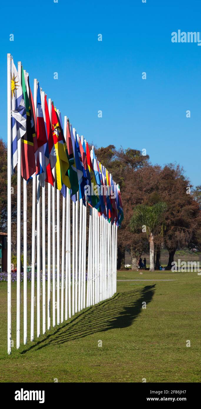 Vertical shot of a row of flagpoles with flags Stock Photo - Alamy