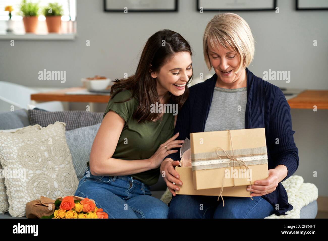 Mother unpacking a gift with her adult daughter Stock Photo - Alamy