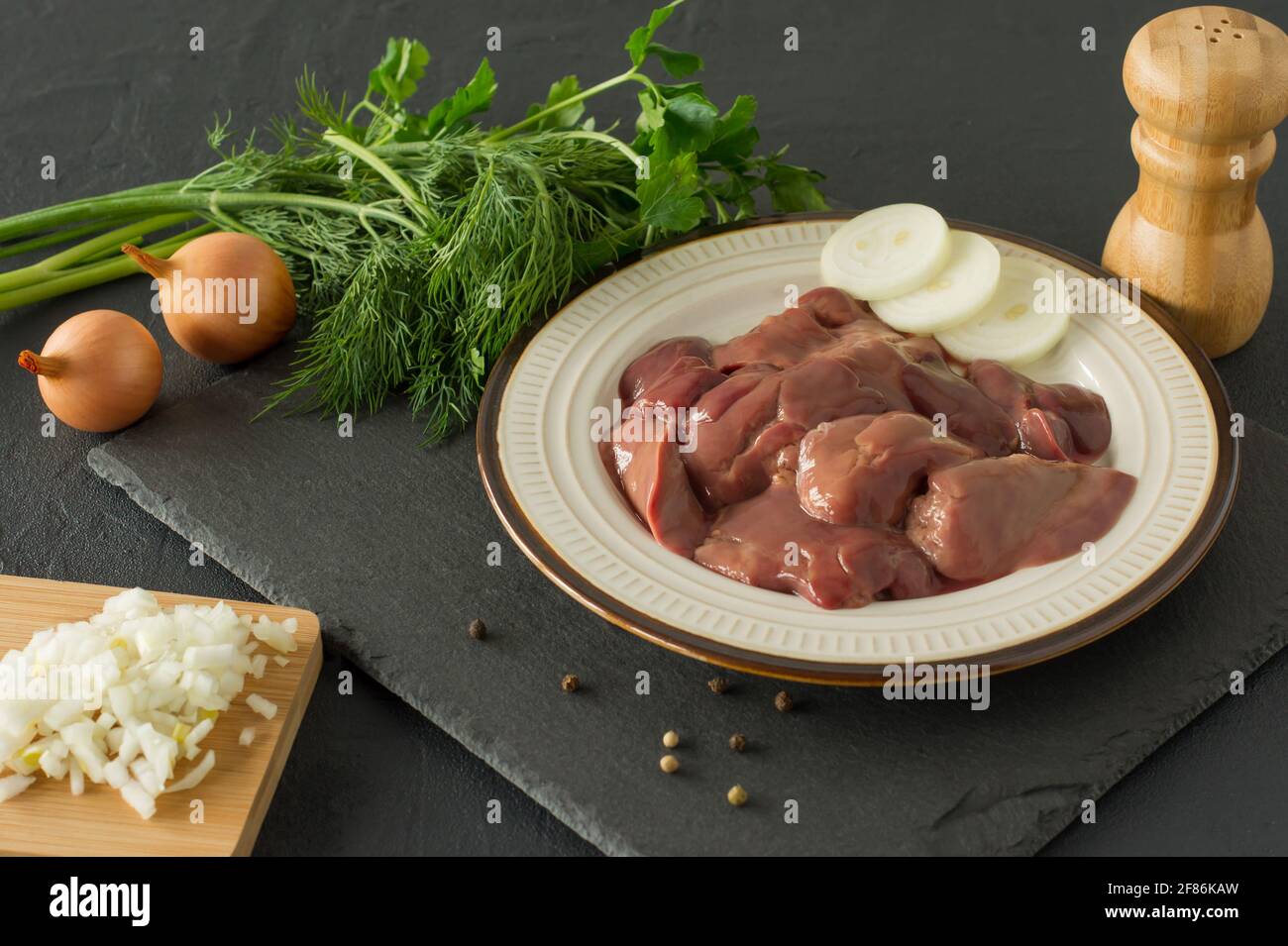Raw chicken liver in bowl on black background. Ingredients for cooking ...